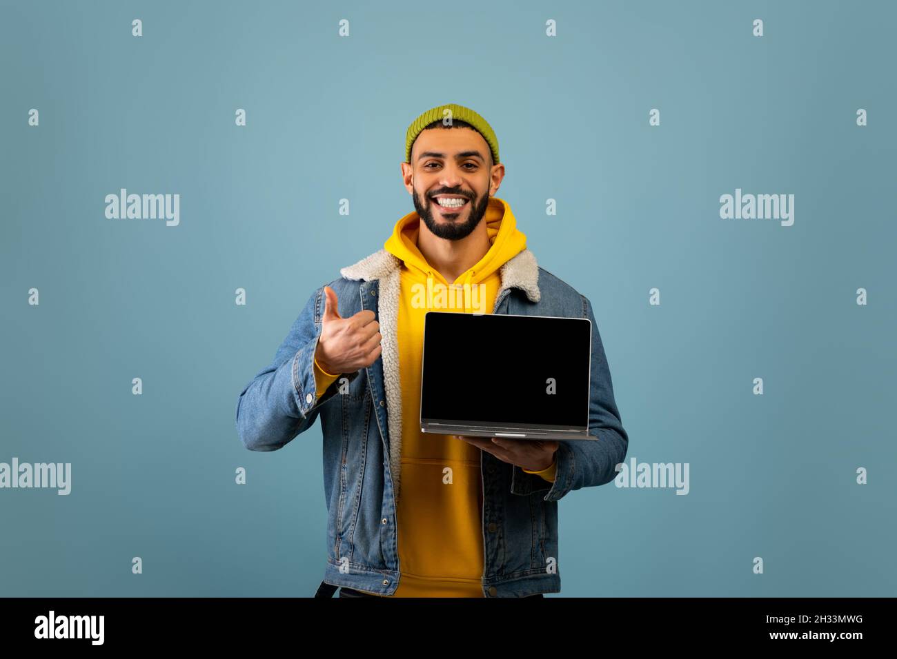 Happy arab guy recommending newest computer software, showing thumb up ...