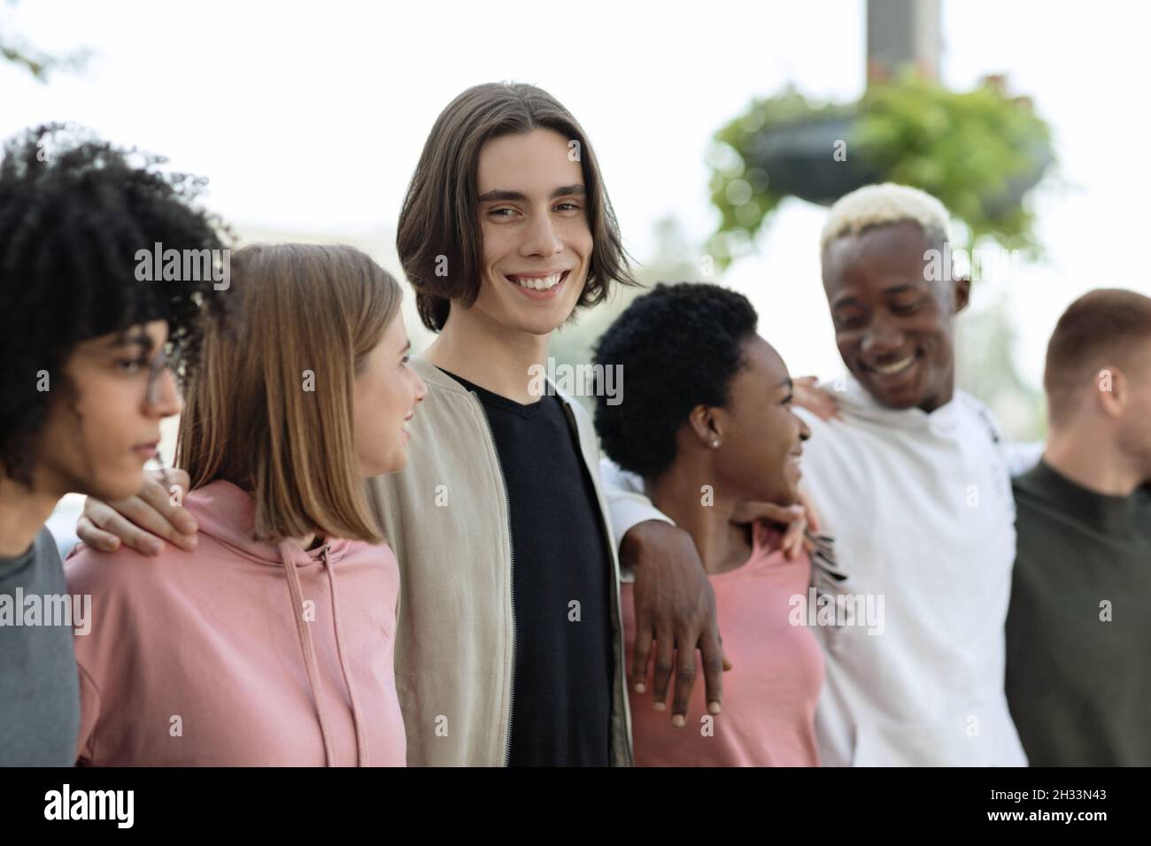 Cheerful handsome guy spending time with his international friends men ...