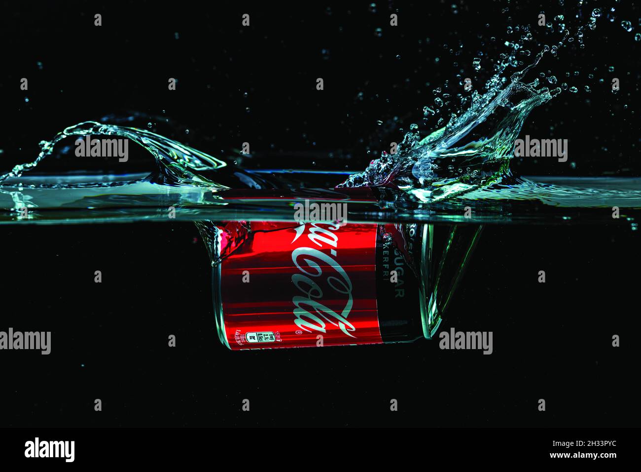 Close up view of can of Coca cola falling into water isolation on black ...