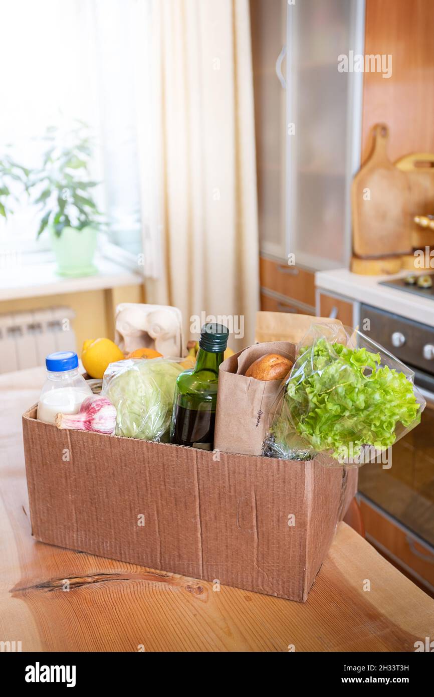 Cardboard box with fresh packed food products on wooden table in ...