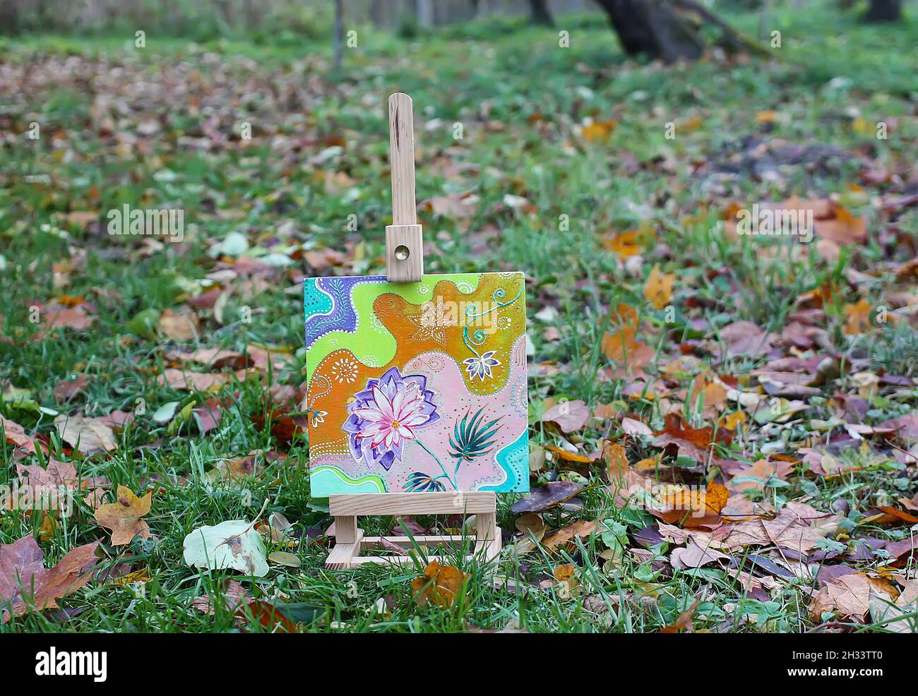 Easel with paints and painting on canvas in autumn park Stock Photo - Alamy