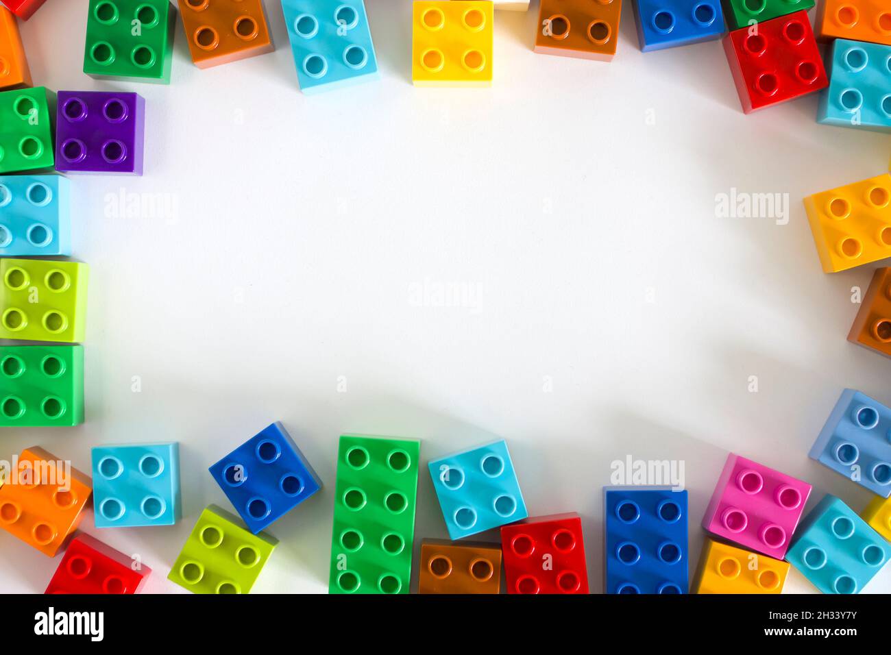 Colorful plastic building blocks with empty copyspace on white ...