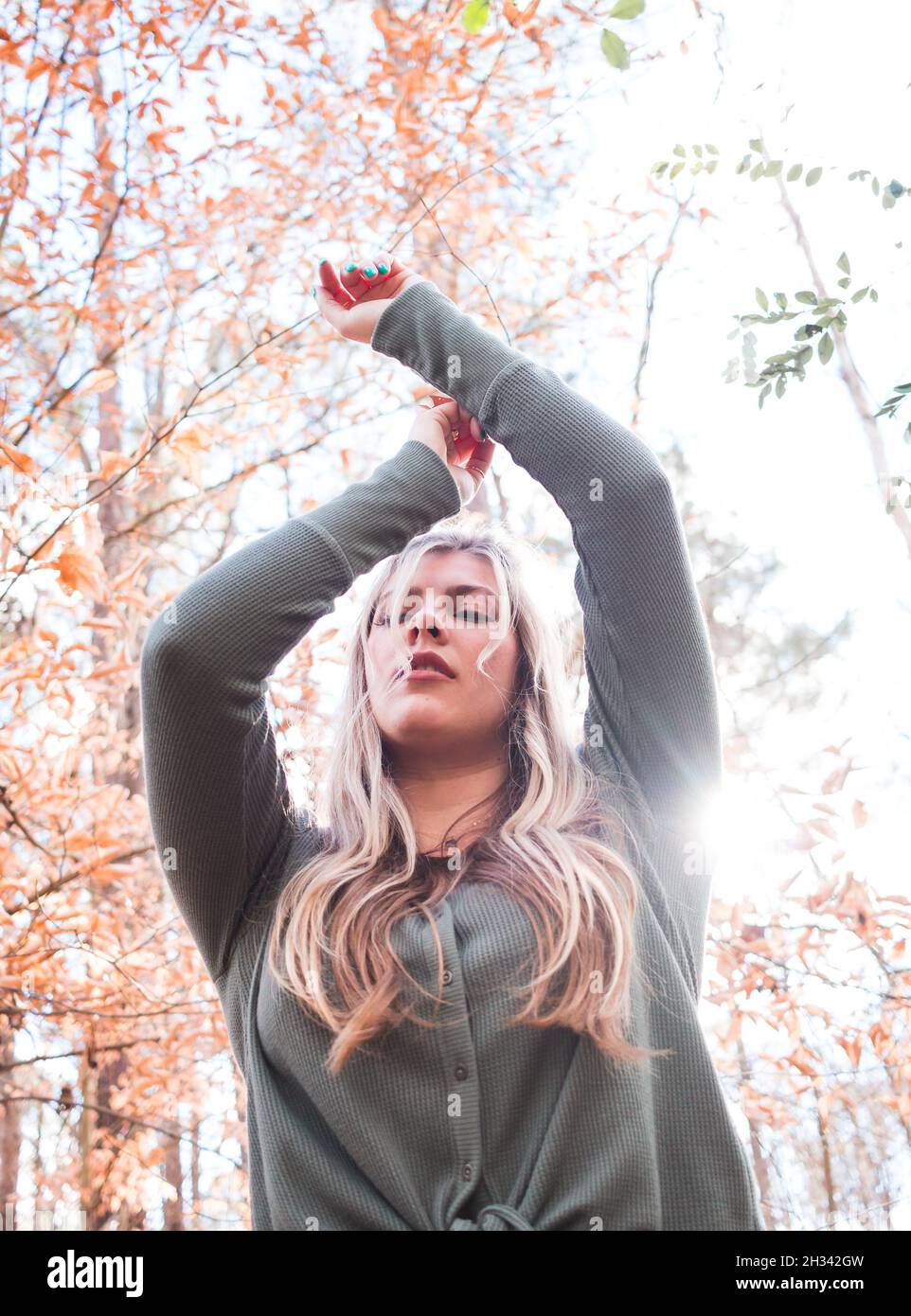 Stylish female model posing in the woods enjoying the fall or autumn ...