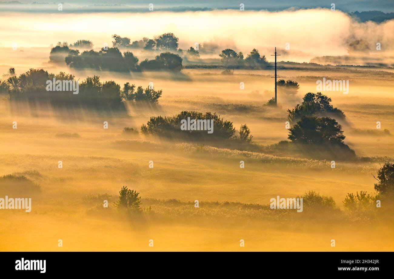 Beautiful panoramic landscape with river valley covered by thick fog in ...