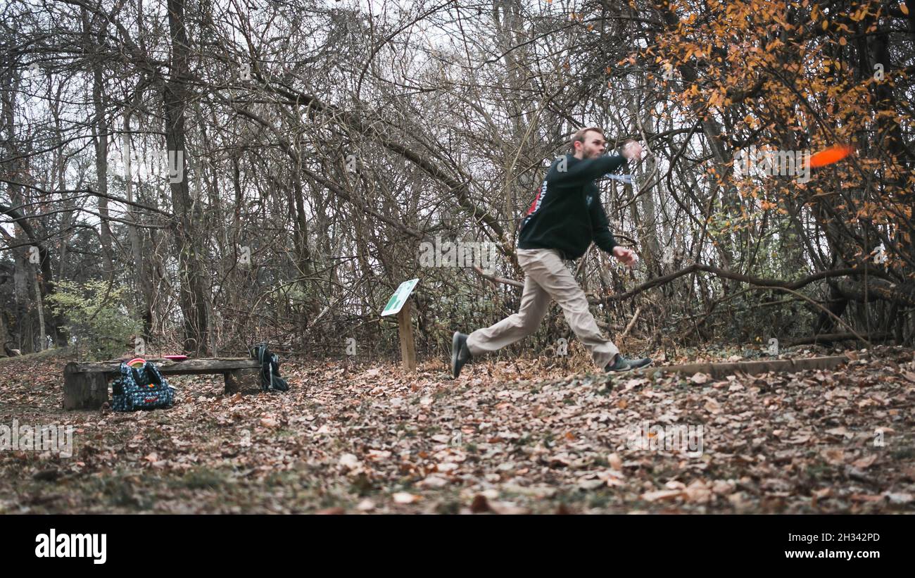 Athletic young man playing disc golf in the woods during winter Stock ...