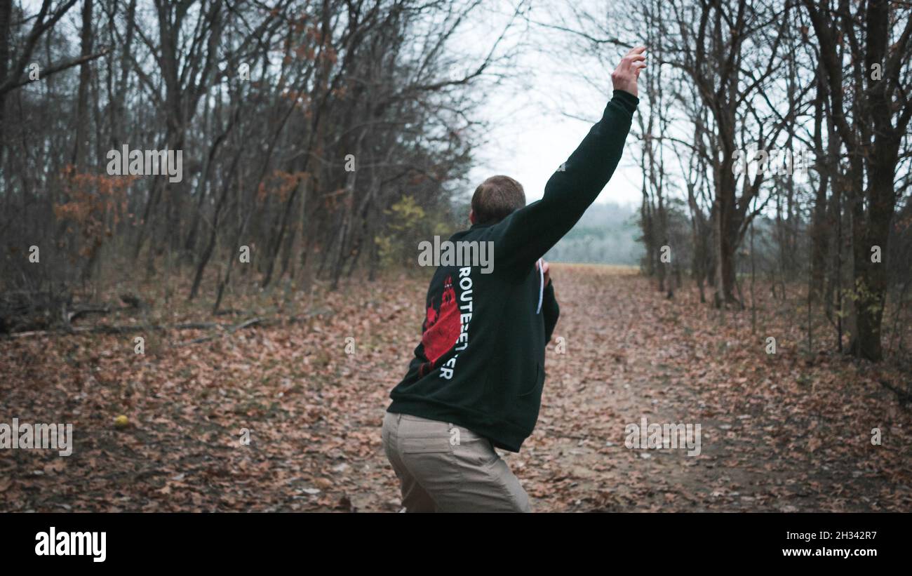 Athletic young man playing disc golf in the woods during winter Stock ...