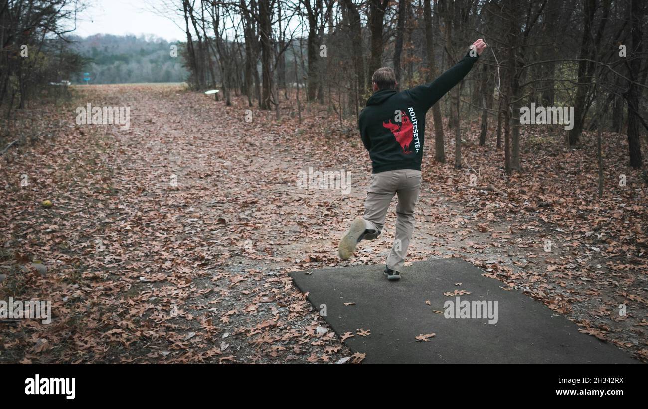 Athletic young man playing disc golf in the woods during winter Stock ...