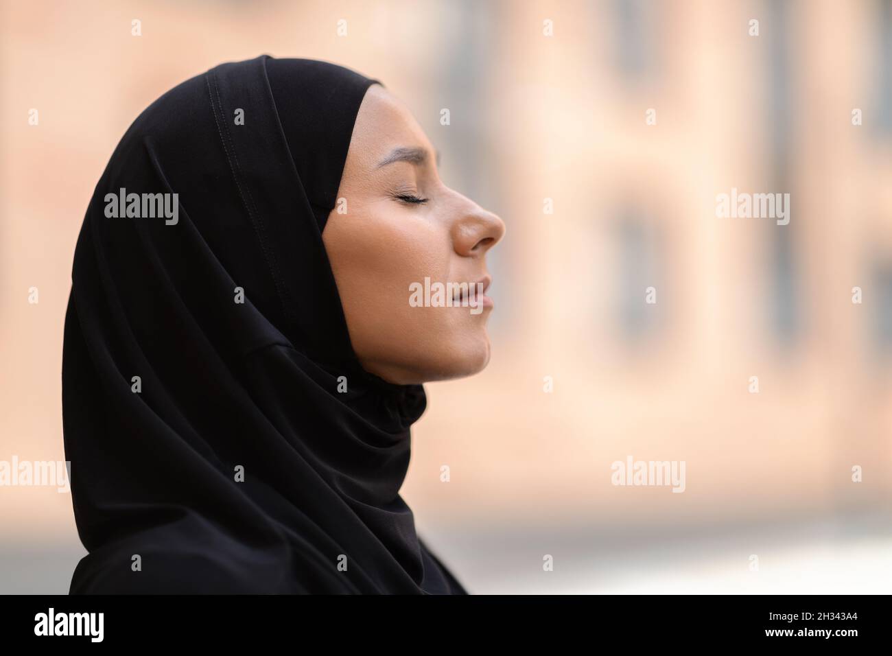 Outdoor Profile Portrait Of Calm Young Muslim Woman In Black Hijab ...