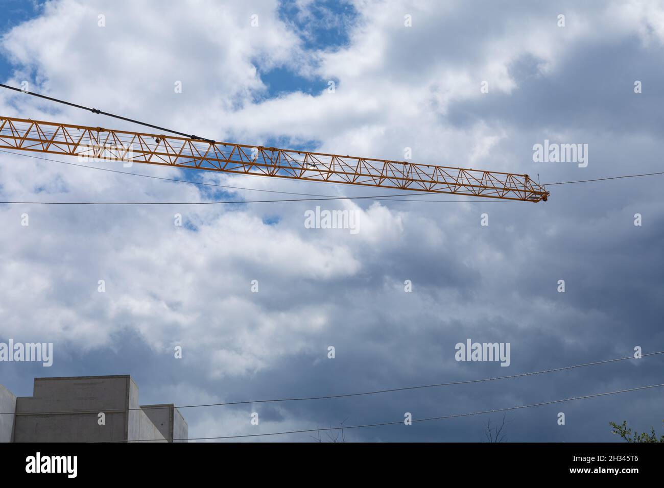 Extended arm of a large construction crane before stormy skies with ...