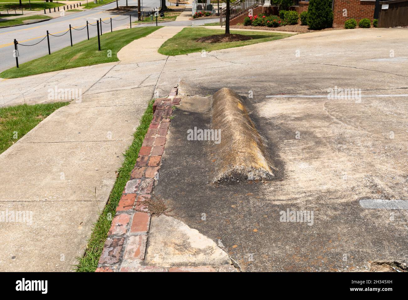 Sloping parking lot and drive leading to a sidewalk and well tended ...