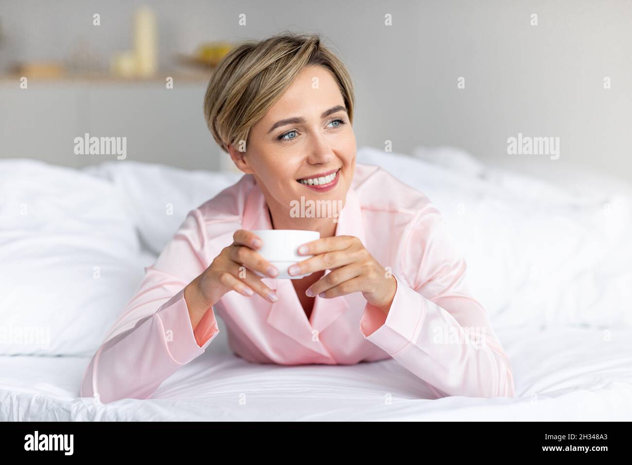 Good Morning. Portrait of relaxed smiling woman lying in comfortable ...