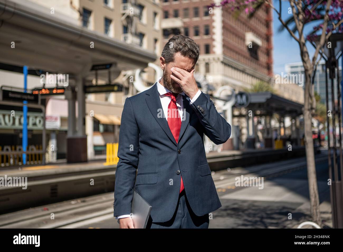 tired freelance man hold pc outdoor, overworked Stock Photo - Alamy