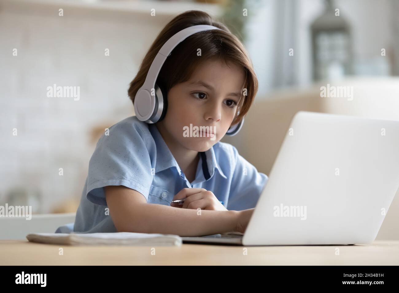 Serious gen Z boy in headphones studying from home Stock Photo - Alamy