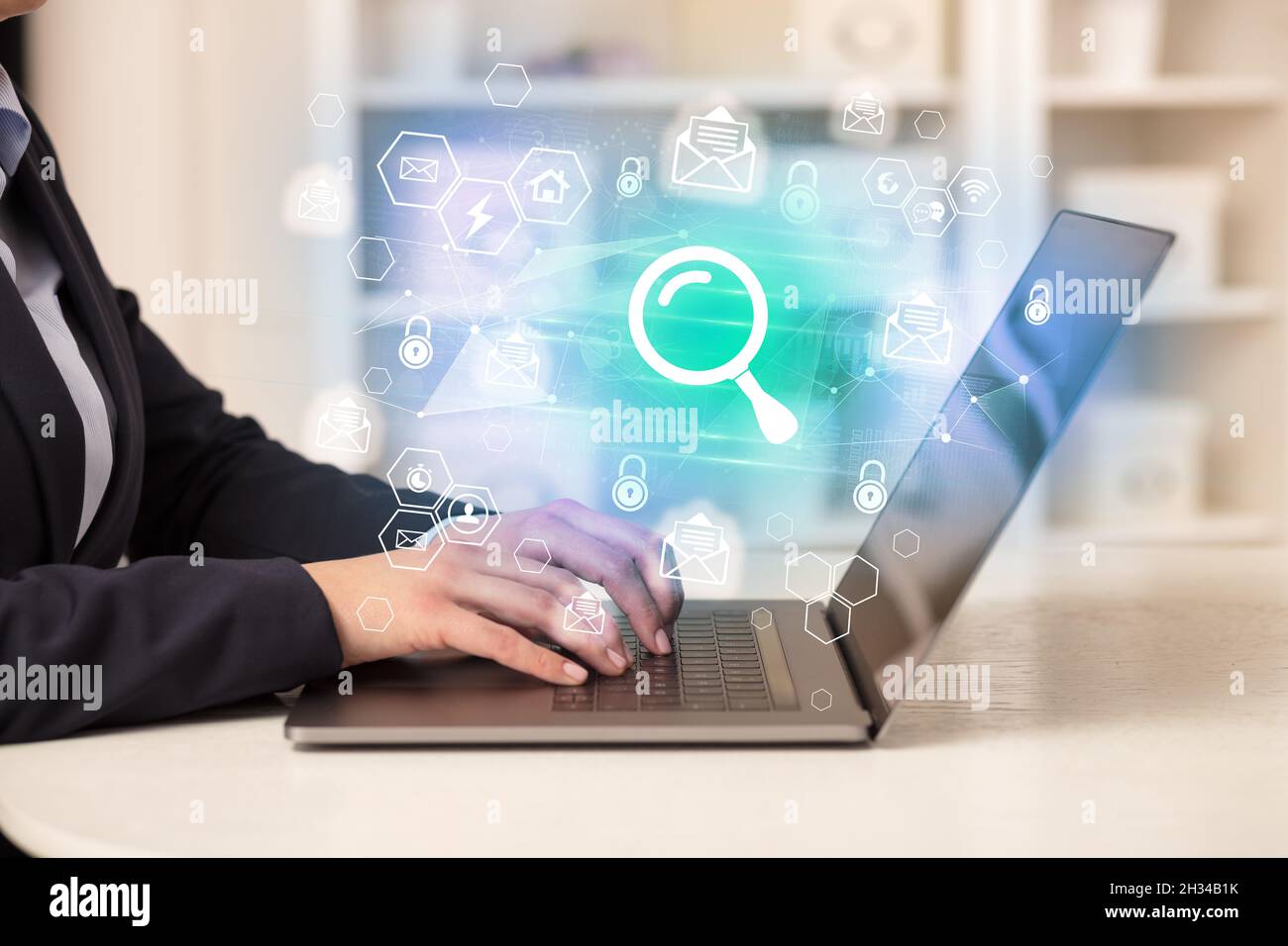 Hands working on laptop with digital icons Stock Photo - Alamy