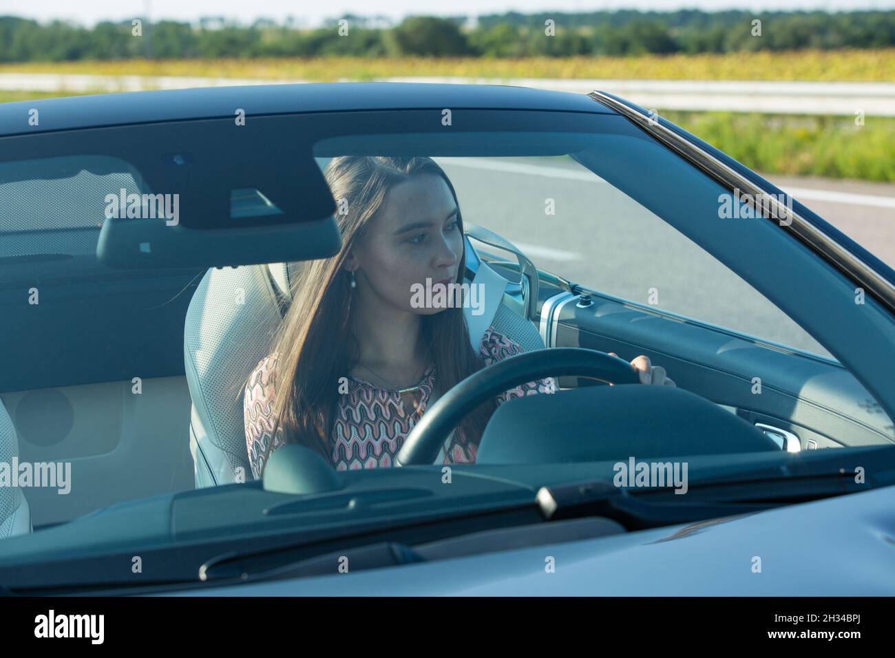Beautiful young woman driving a Mercedes Benz SL550 convertible on the ...