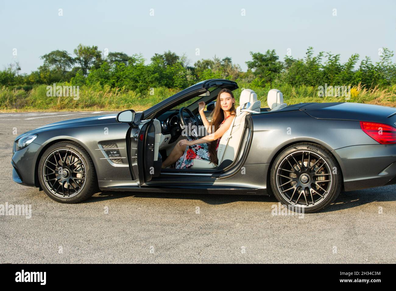 Beautiful young woman in the driver's seat of a Mercedes Benz SL550 ...