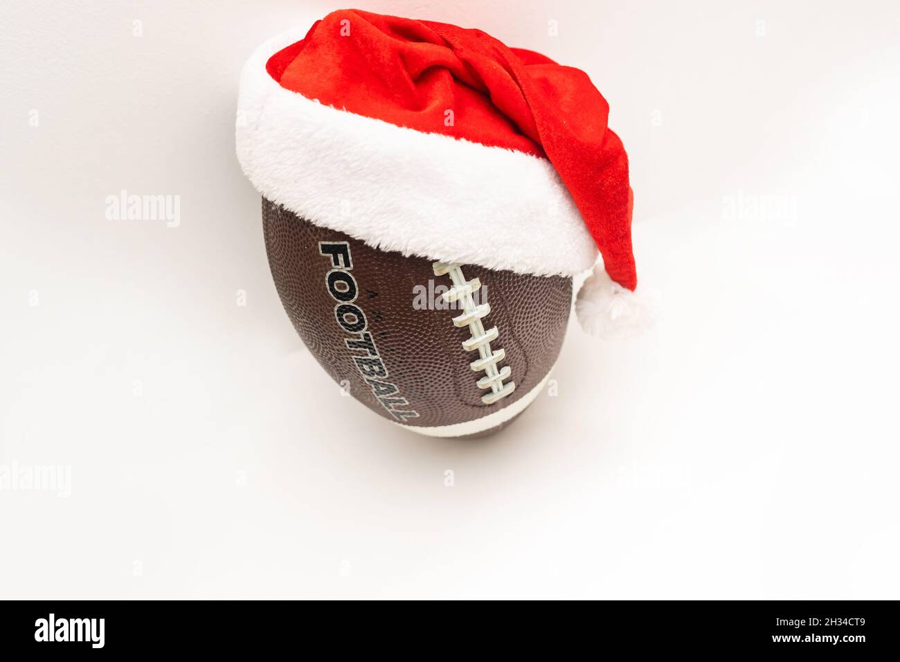 A souvenir ball for rugby or american football in a red santa claus hat ...