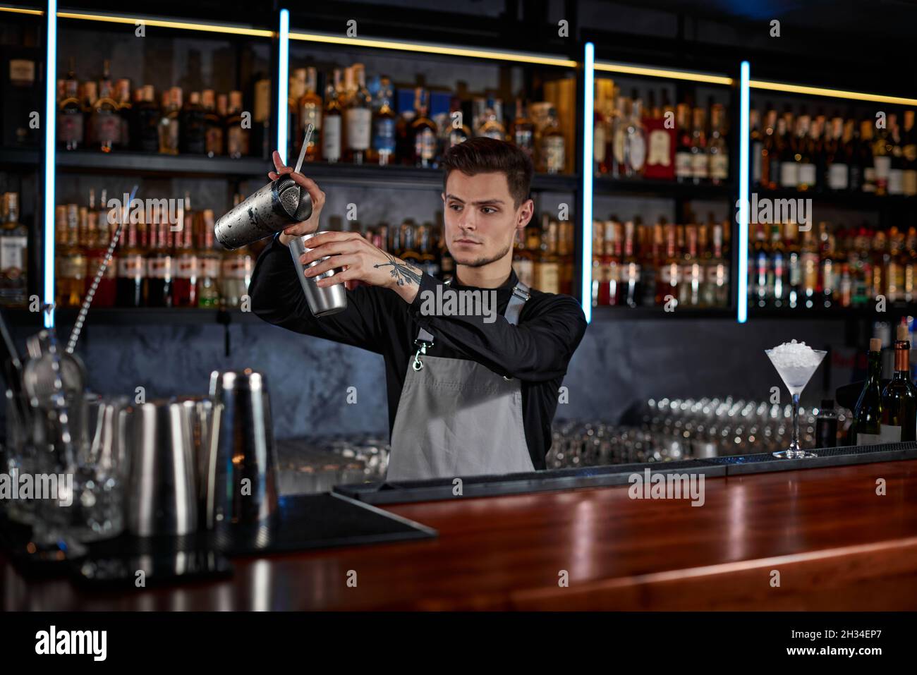 barman is making cocktail with steel shaker Stock Photo - Alamy