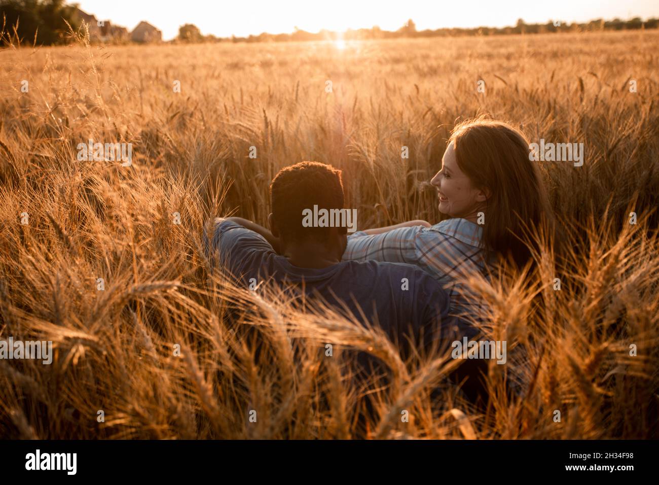 Hugging couple meeting sunset in a wheat field Stock Photo - Alamy