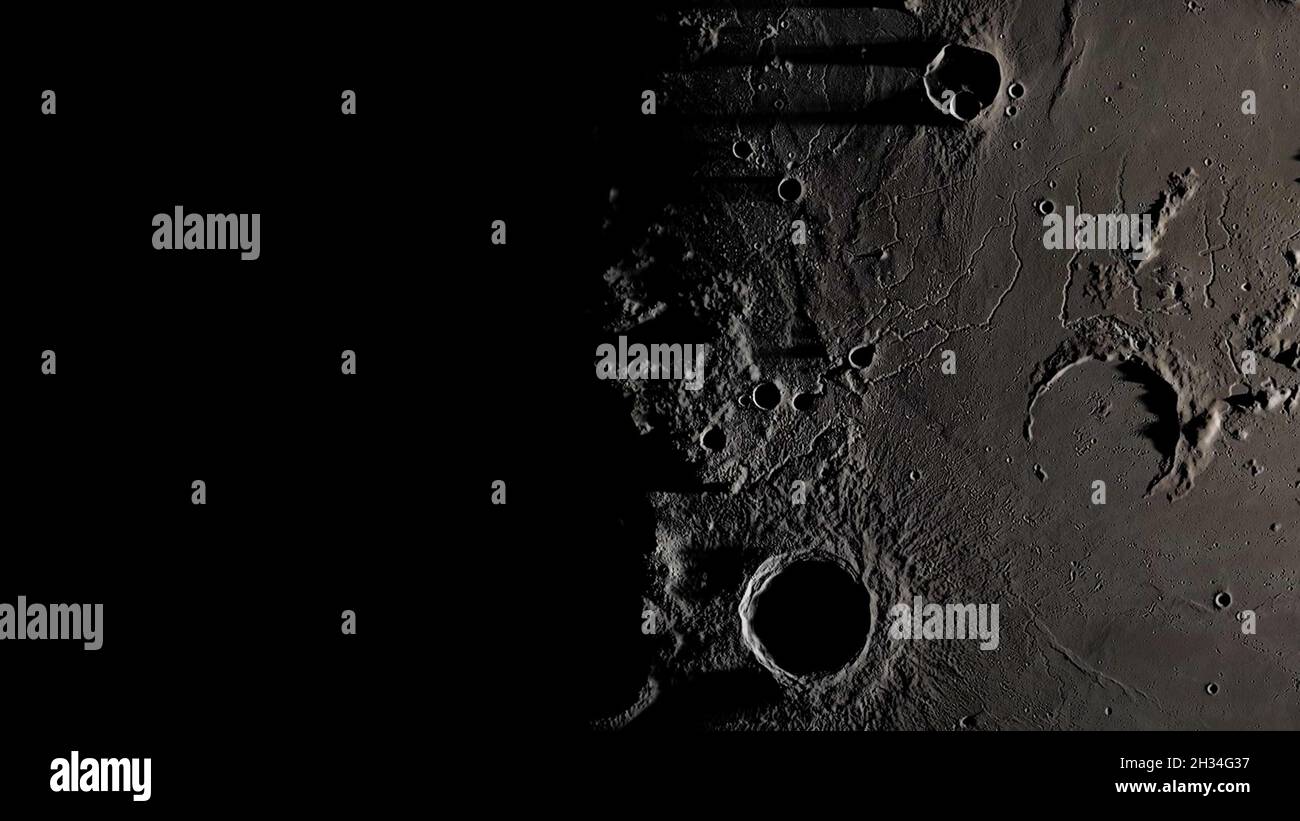 The moon's surface is partially illuminated by sunlight. The surface of ...
