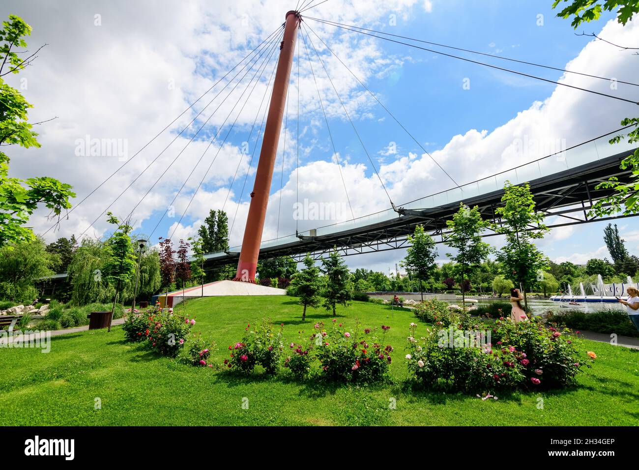 Landscape with the modern red metallic bridge, lake and vivid green ...