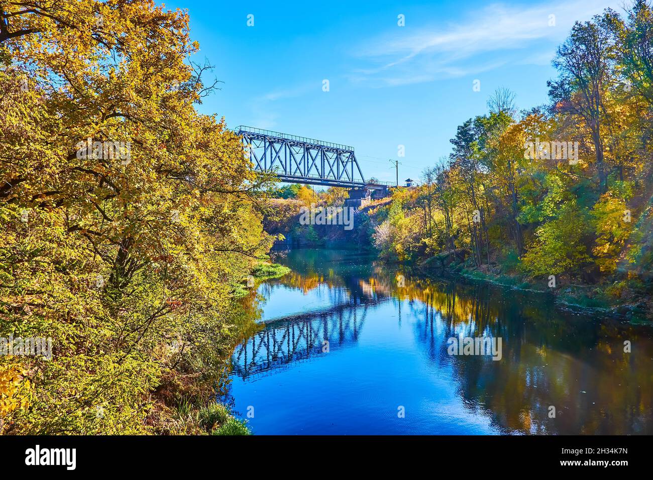 The old metal railway bridge over Uzh river is seen from Drevlians Park ...