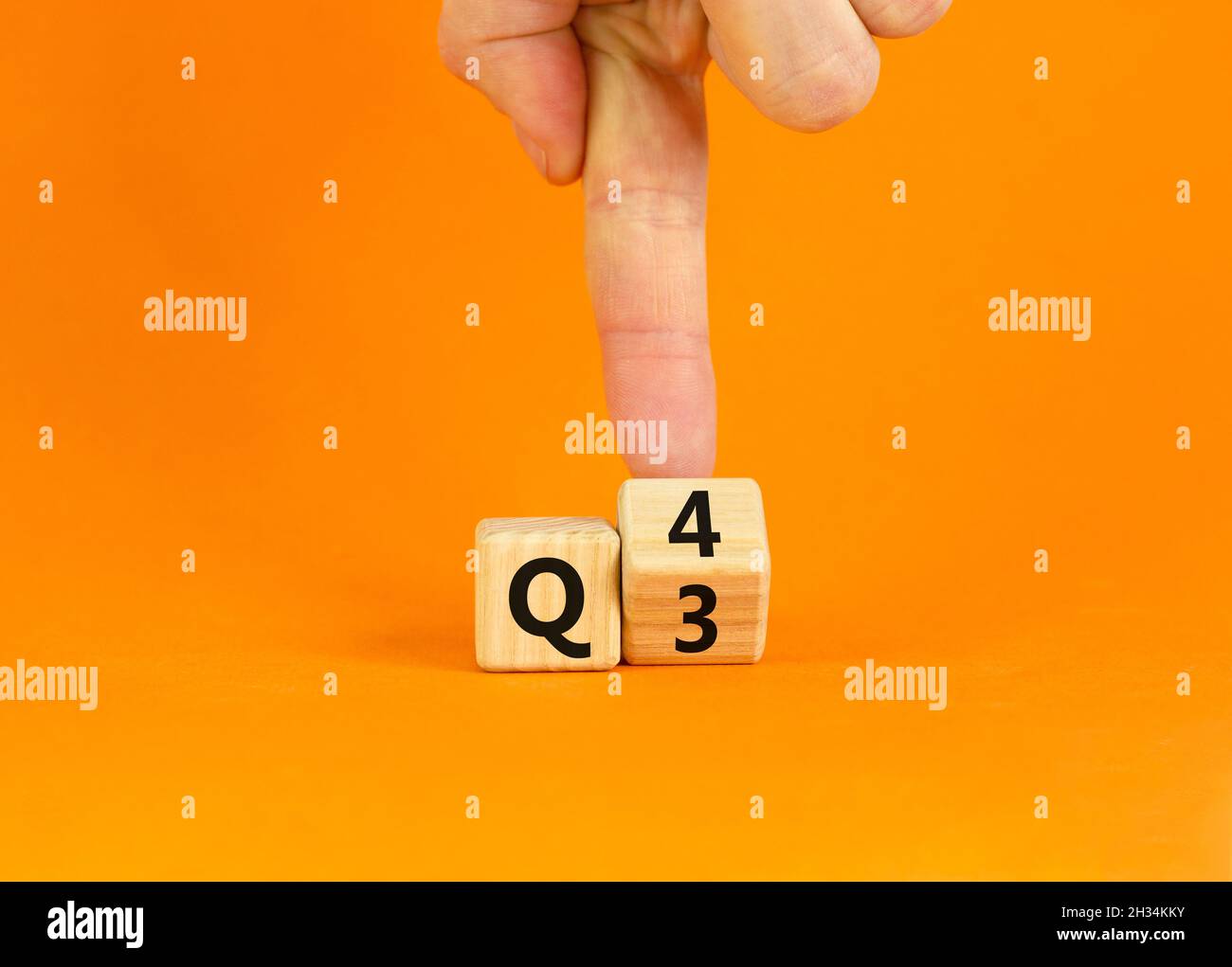 From 3rd to 4th quarter symbol. Businessman turns a wooden cube and ...