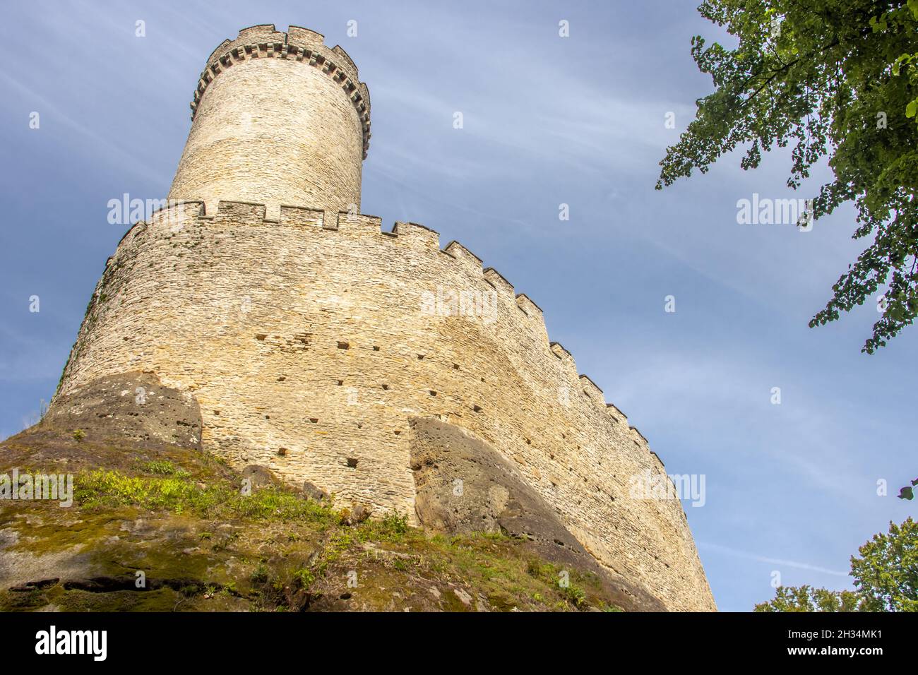 A circular stone tower behind the walls with the battlements of a ...