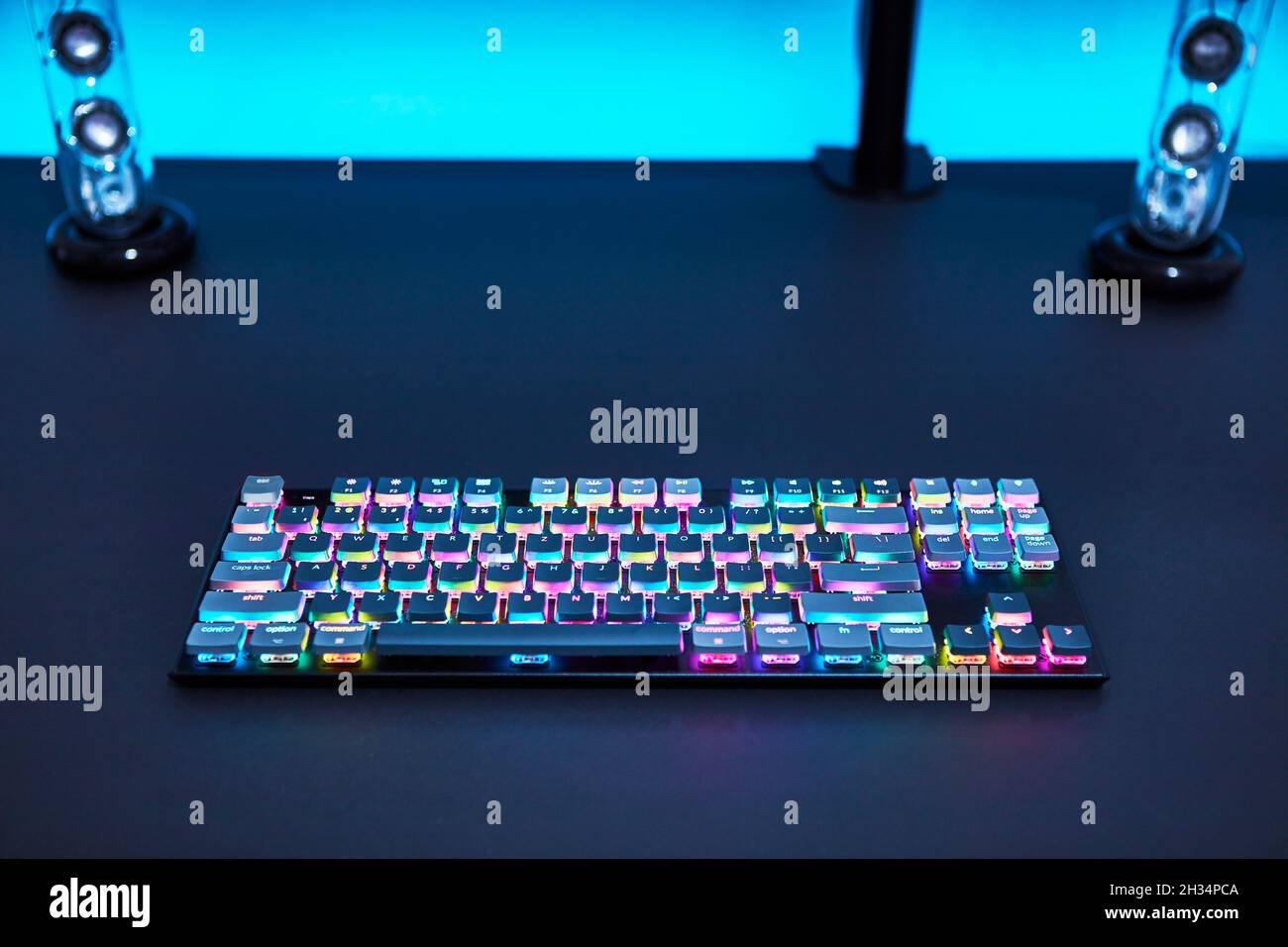 Color backlighted gaming computer keyboard laying on grey desk. Blue ...