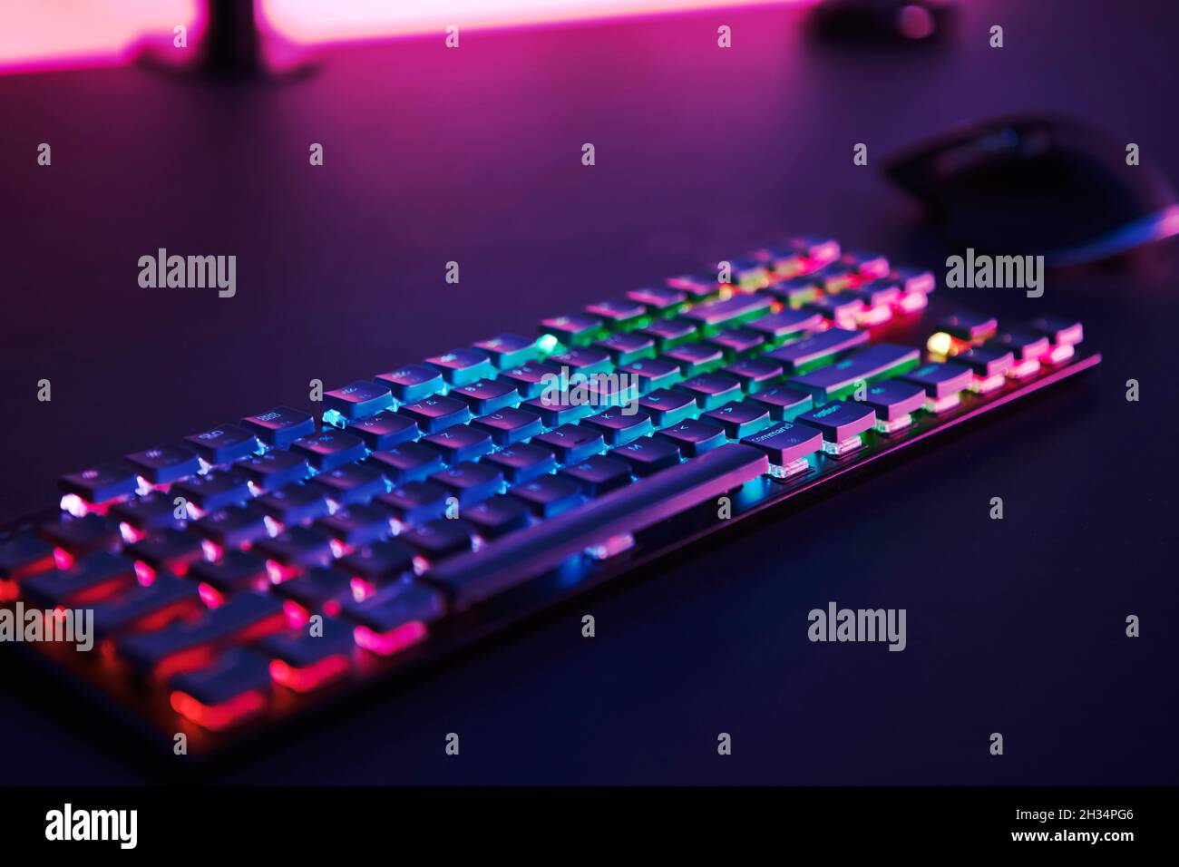 Rainbow color backlighted gaming computer keyboard on dark table ...