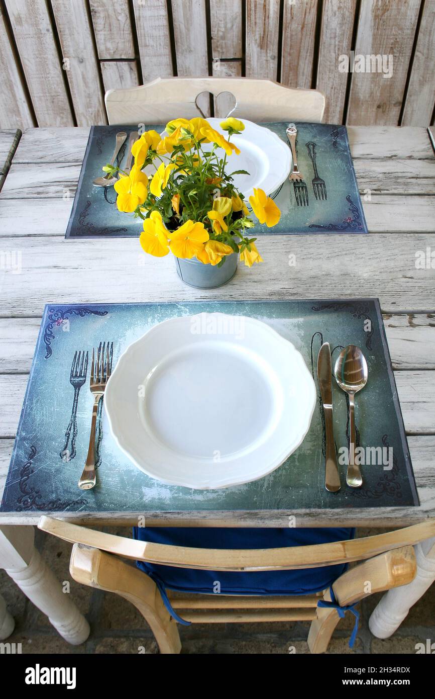 Wooden table for two with lovely flowers set for lunch Stock Photo - Alamy
