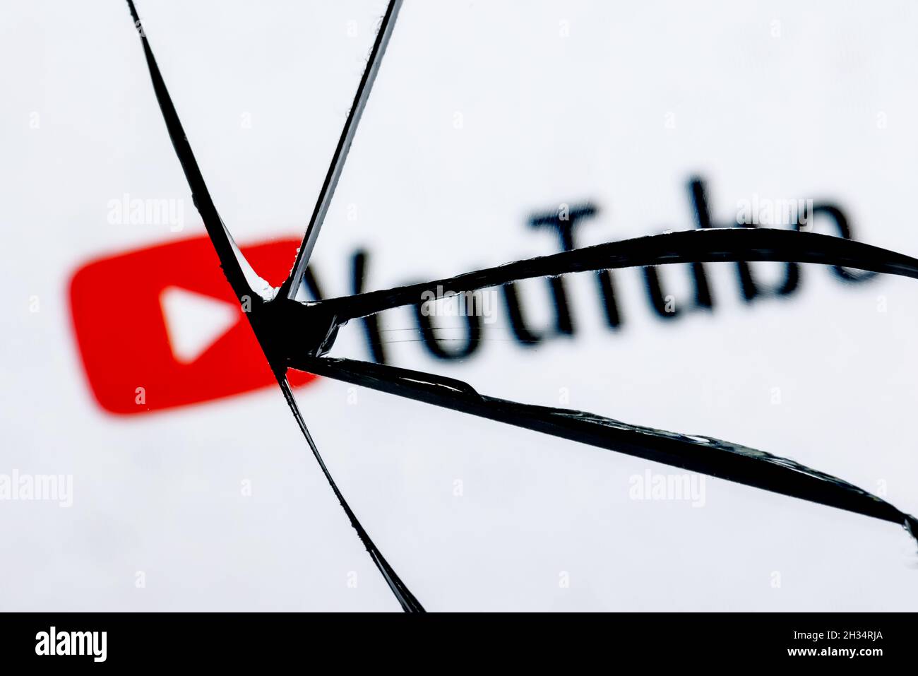 Logo of the Youtube social media platform in the reflection of a broken ...