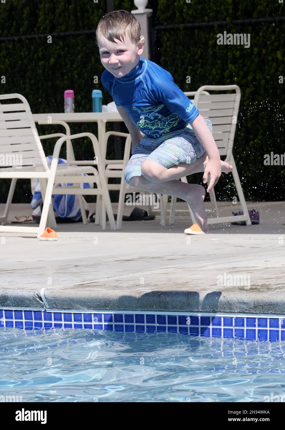 BOY LEAPING INTO THE POOL (RELEASED Stock Photo - Alamy