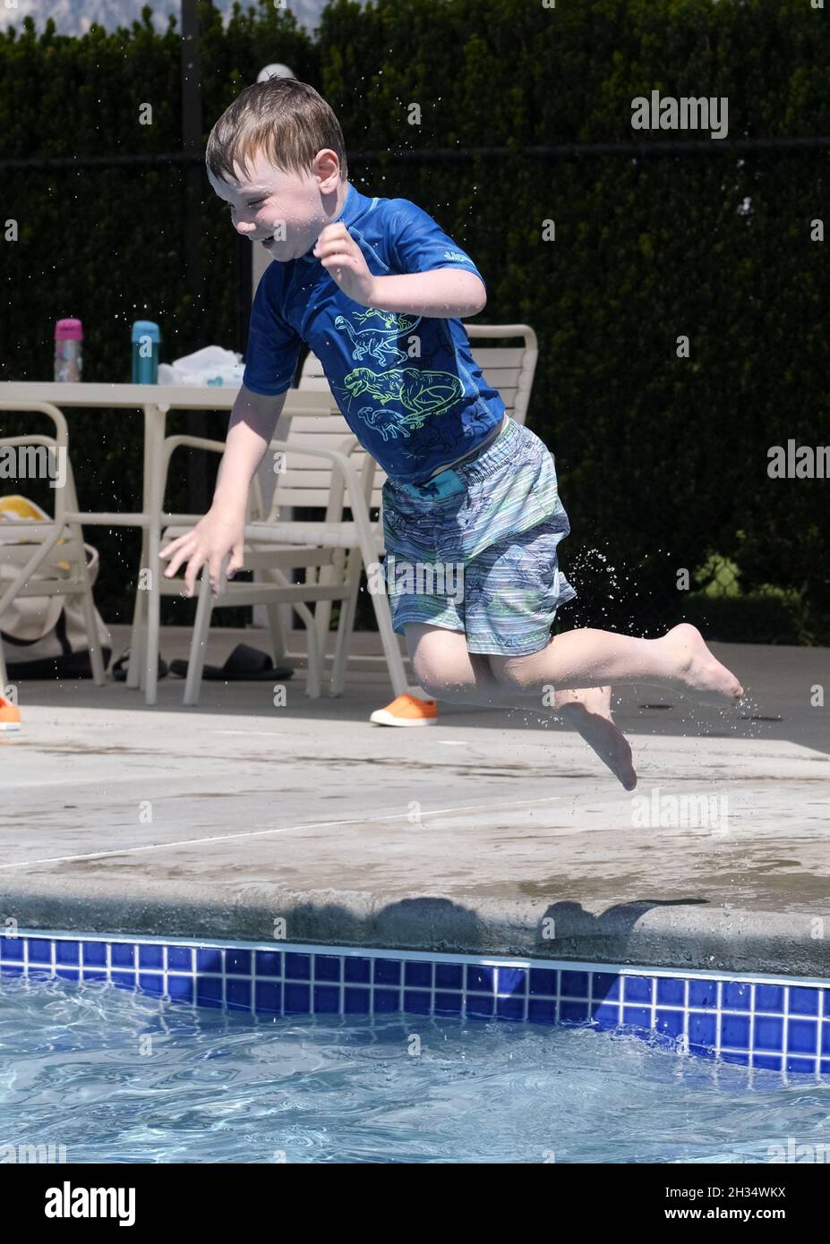 BOY LEAPING INTO THE POOL (RELEASED Stock Photo - Alamy