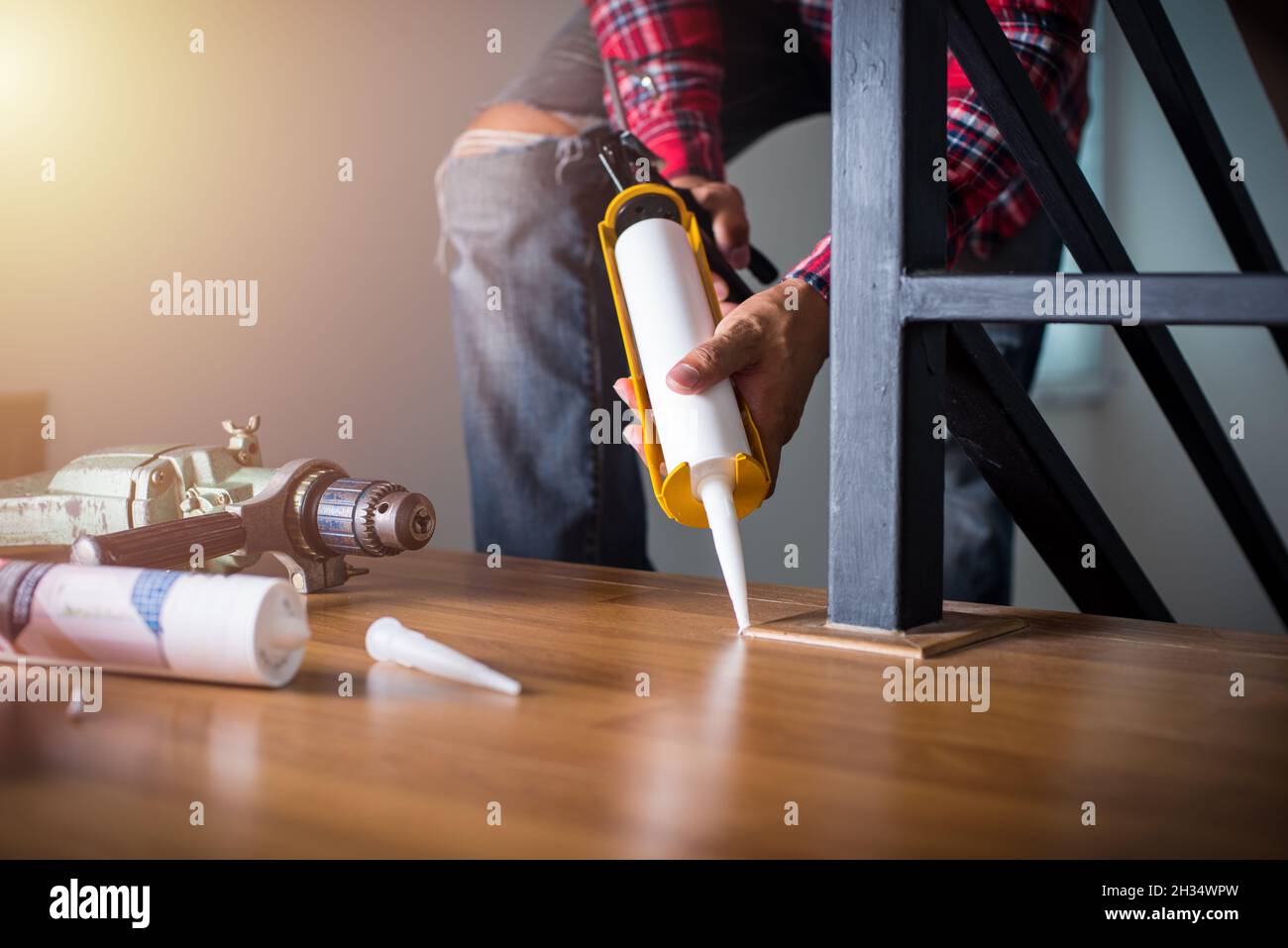 The man applying silicone caulk. The man fixing home Stock Photo - Alamy