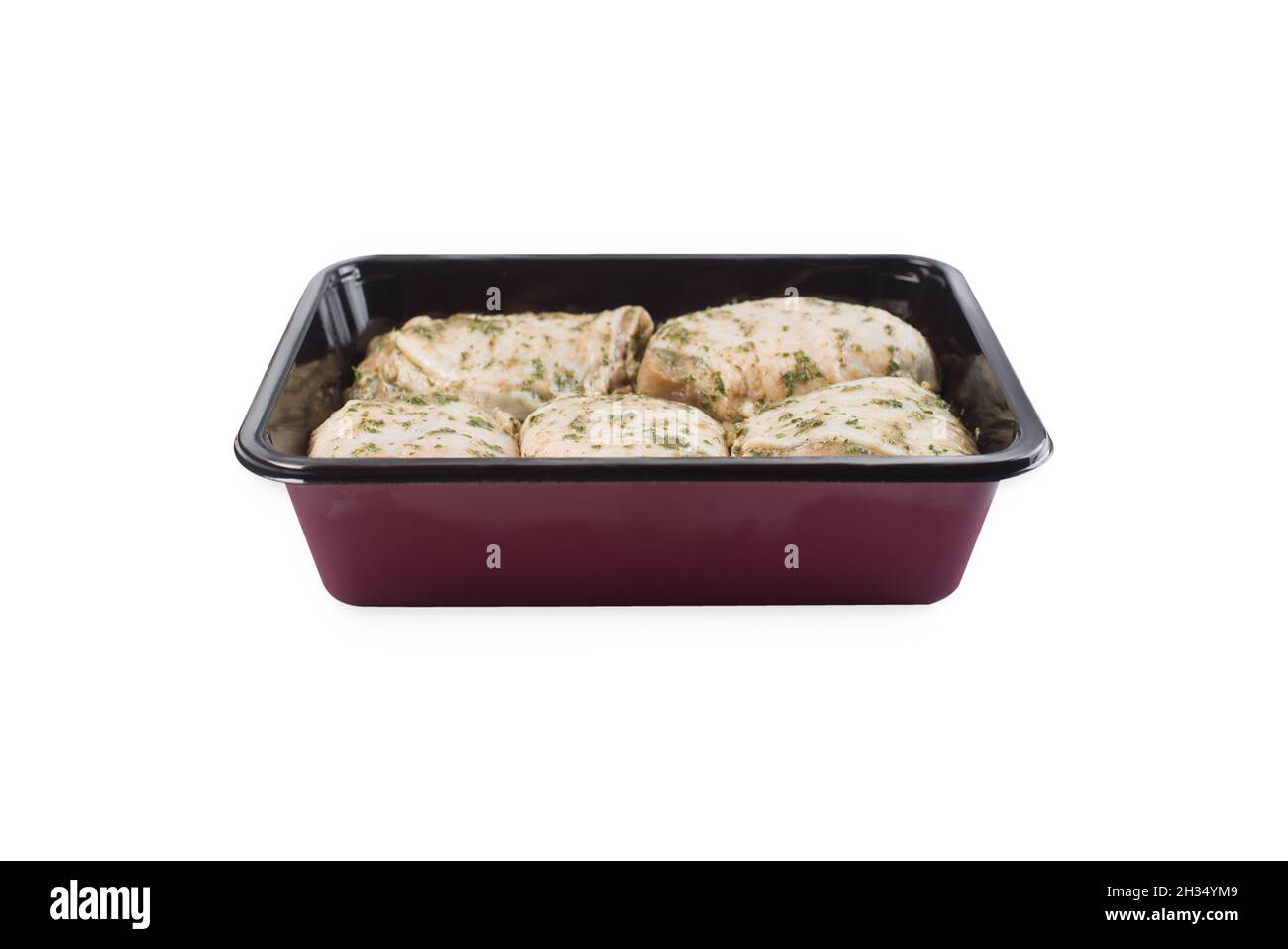 Raw marinated chicken thighs in sauce in a tray for a supermarket, on a ...