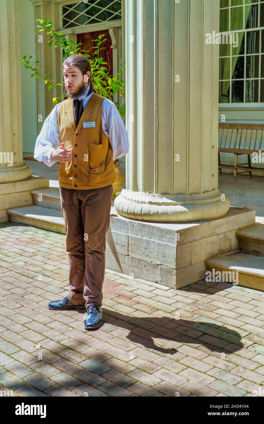 A period costumed guide addresses a tour group in front of Andrew ...