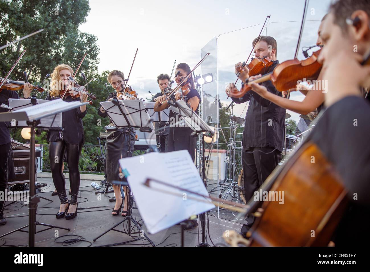 Violin players playing classic instrumental music on outdoor stage ...