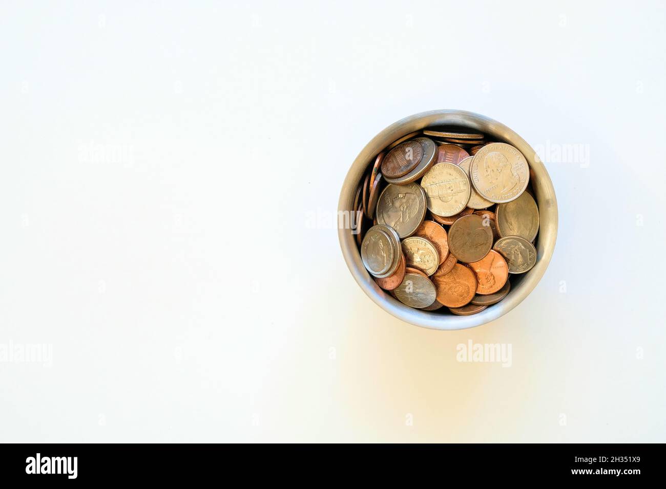 Assorted selection of current use American coins in a chrome cup on a ...