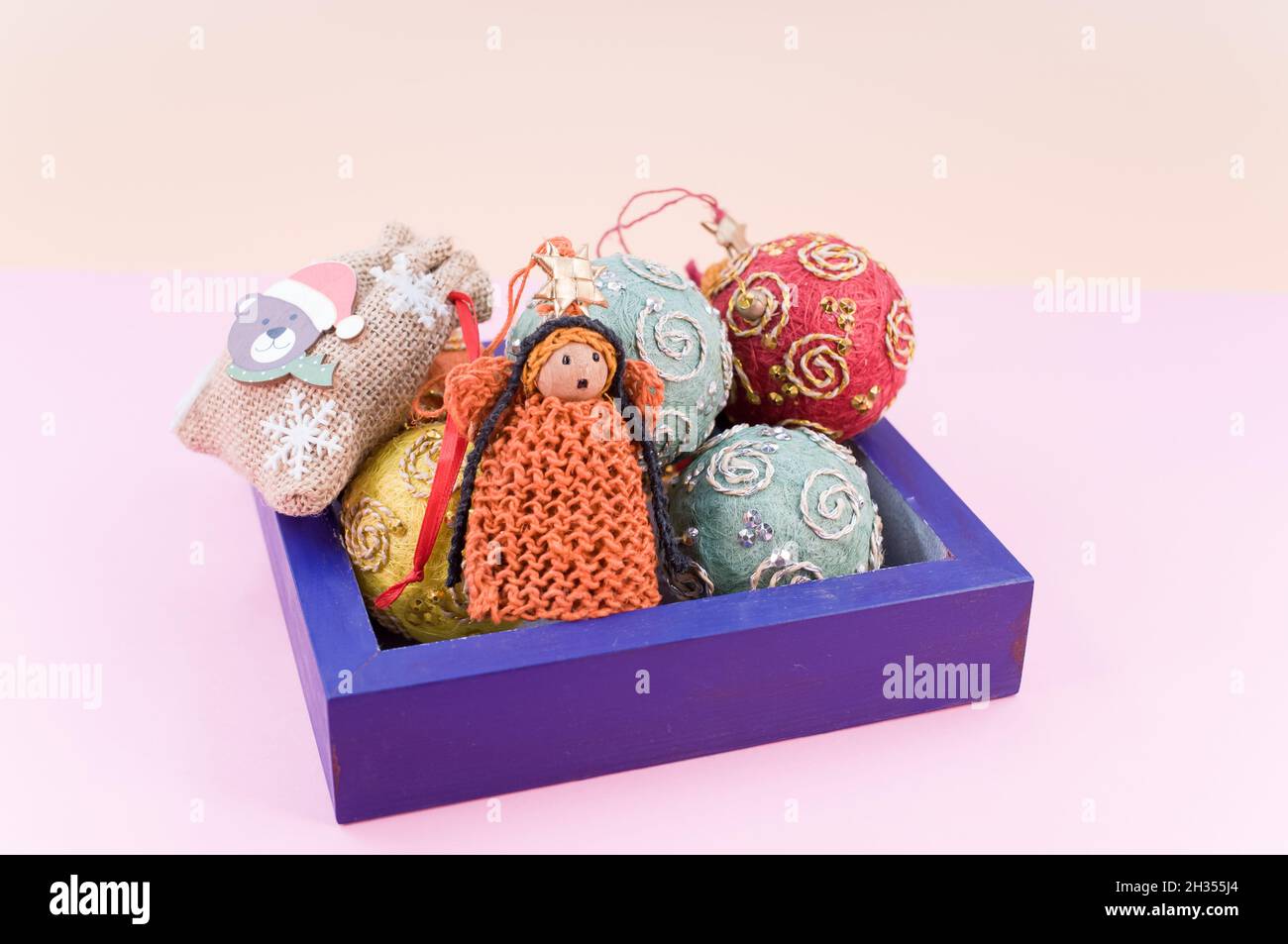 Christmas time decorations in a wooden blue box on a pink background ...
