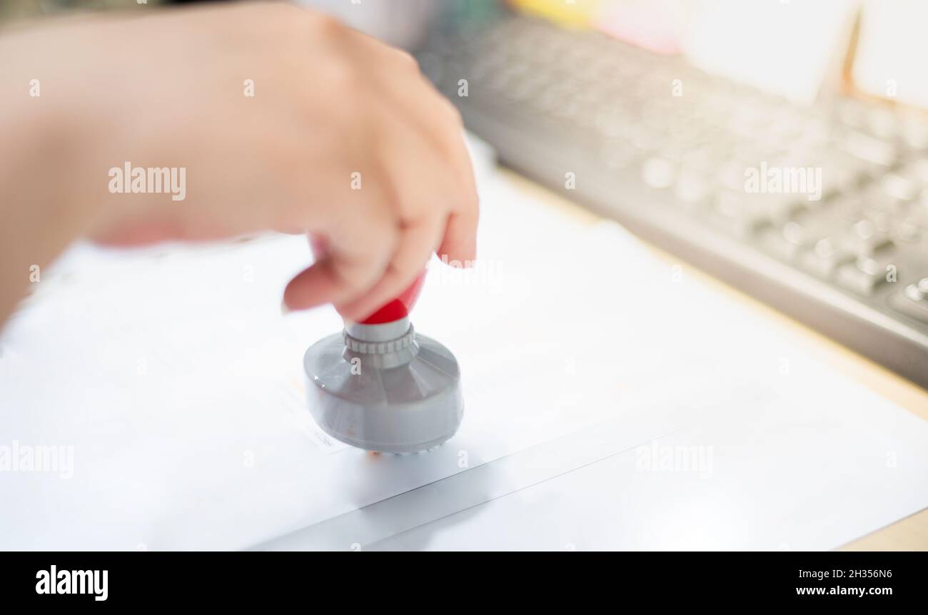 Close-up female hand puts a stamping document for agreement, company ...