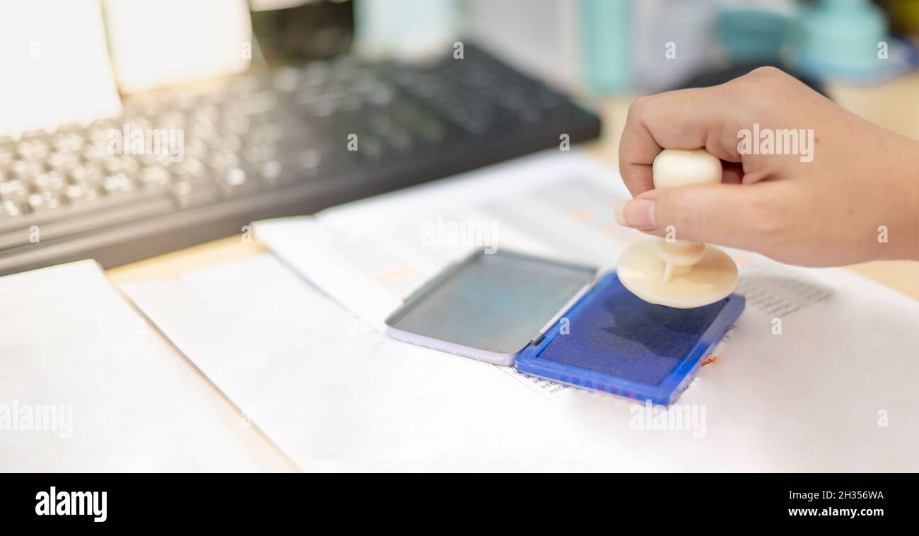 Close-up female hand puts a stamping document for agreement, company ...