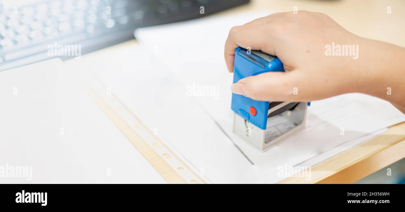 Close-up female hand puts a stamping document for agreement, company ...