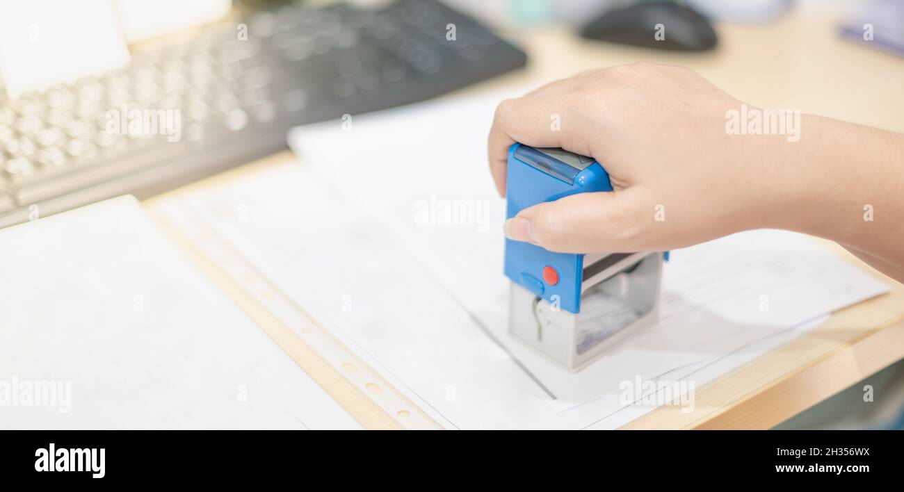 Close-up female hand puts a stamping document for agreement, company ...