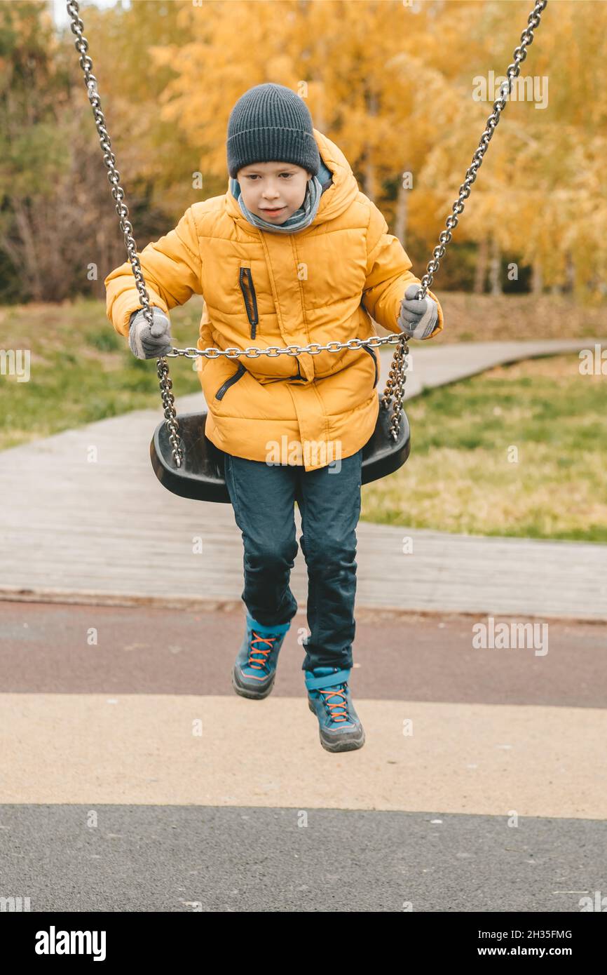 Cute boy swinging in a park hi-res stock photography and images - Alamy