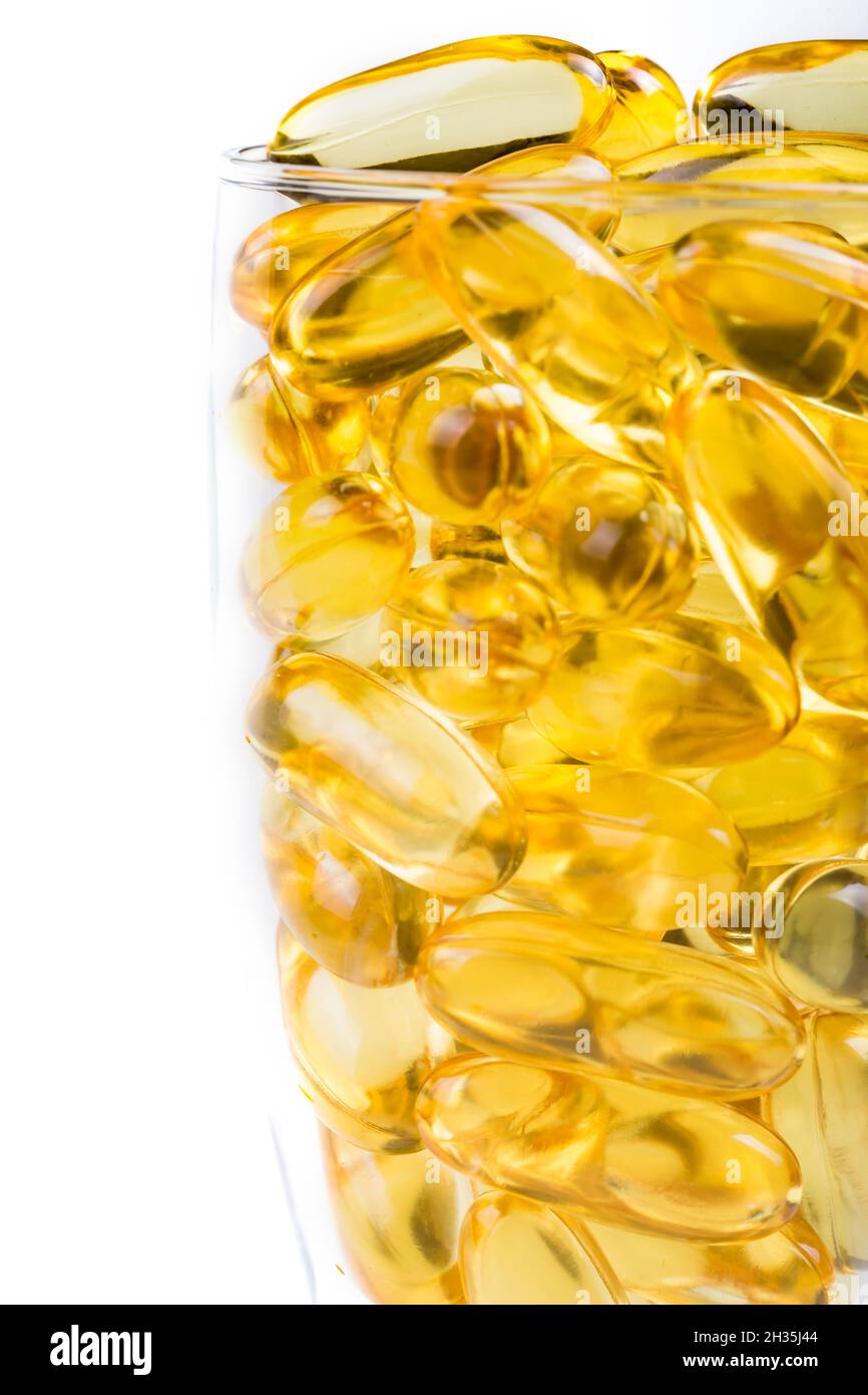 Transparent glass vessel with fish oil orange yellow softgels capsules ...