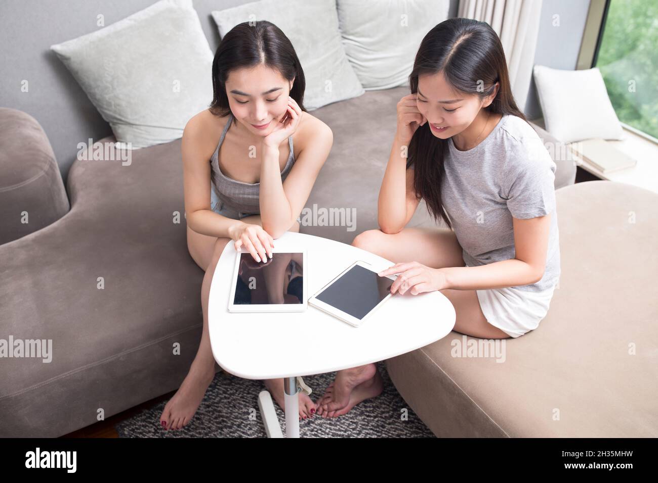 Female friends using digital hi-res stock photography and images - Alamy
