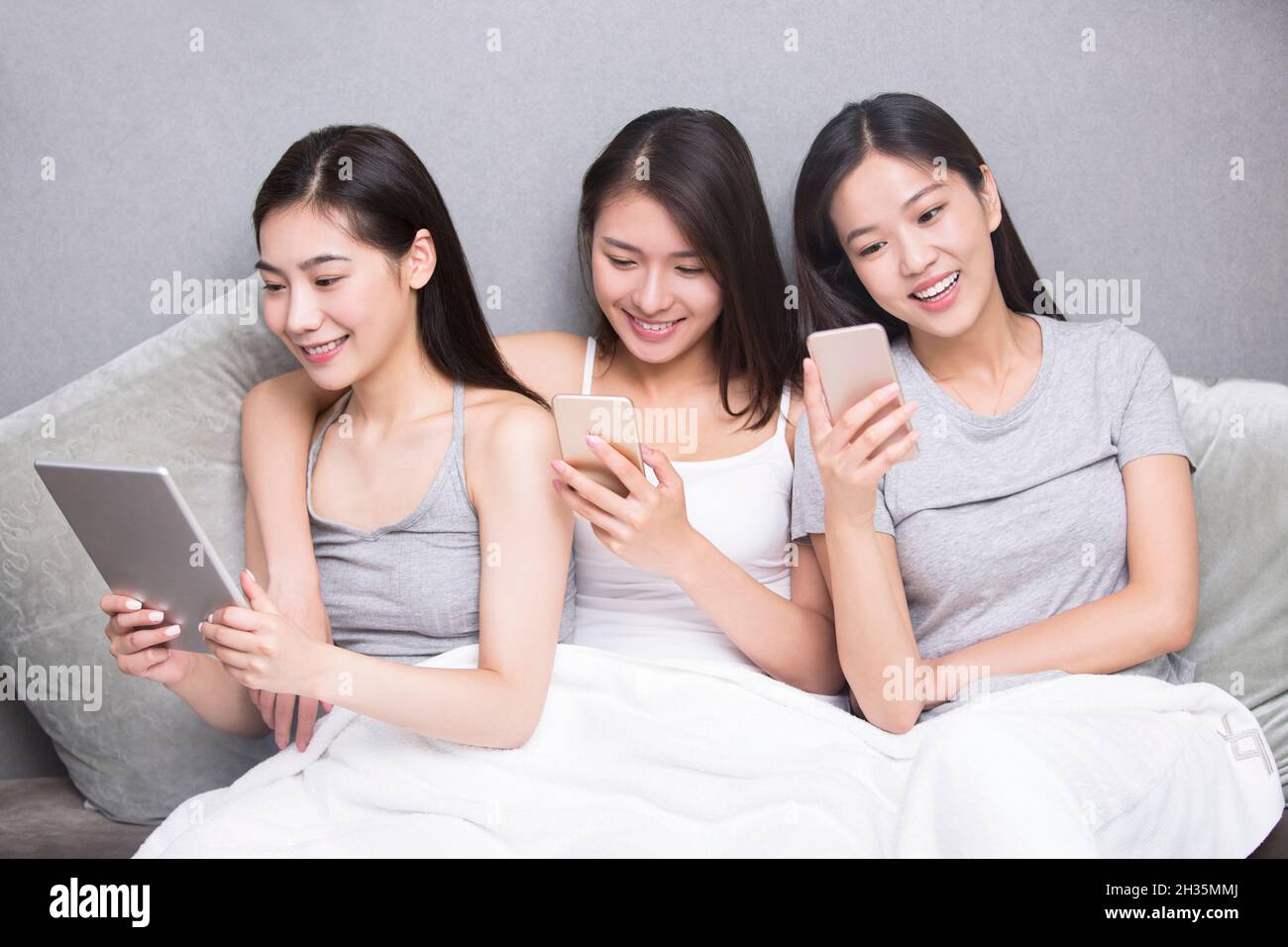 Three best friends using a mobile phone together Stock Photo - Alamy