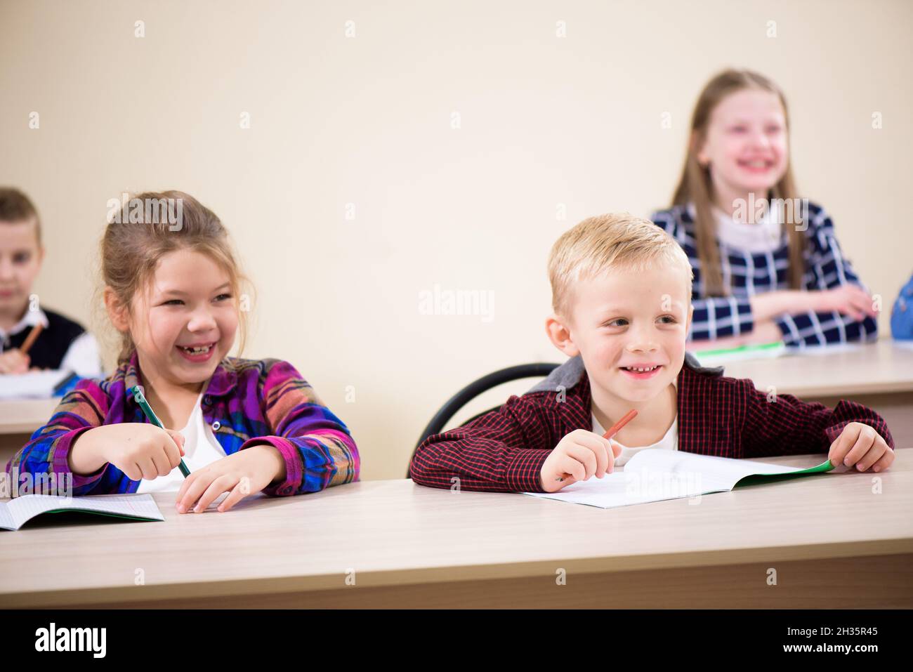 Beautiful children are students together in a classroom in school get ...