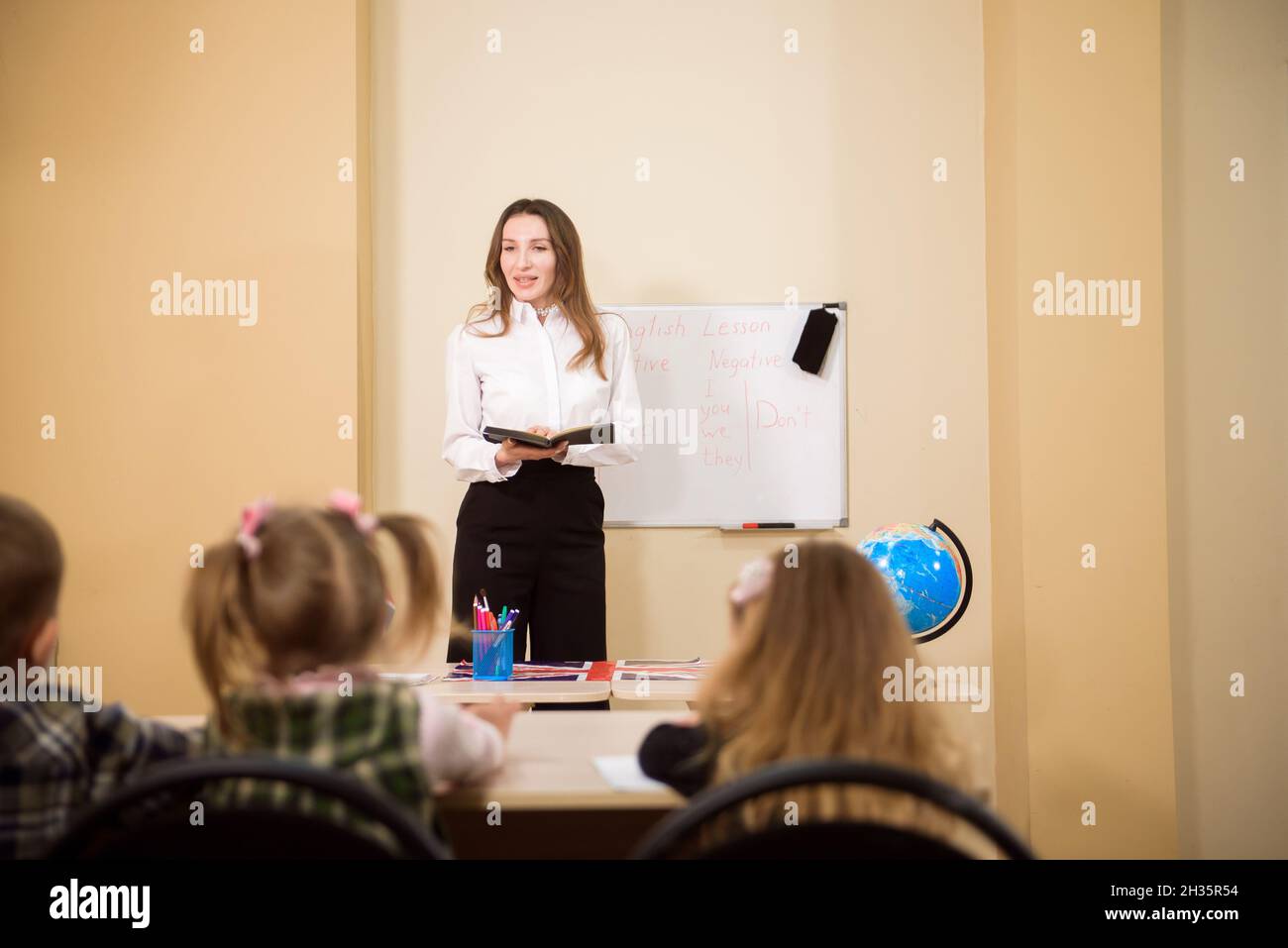Teacher Teaching Lesson To Elementary School Pupils Stock Photo - Alamy